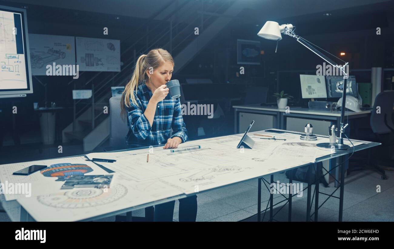 Beautiful Female Engineer Sitting at Her Desk Works and Drinks Coffee ...