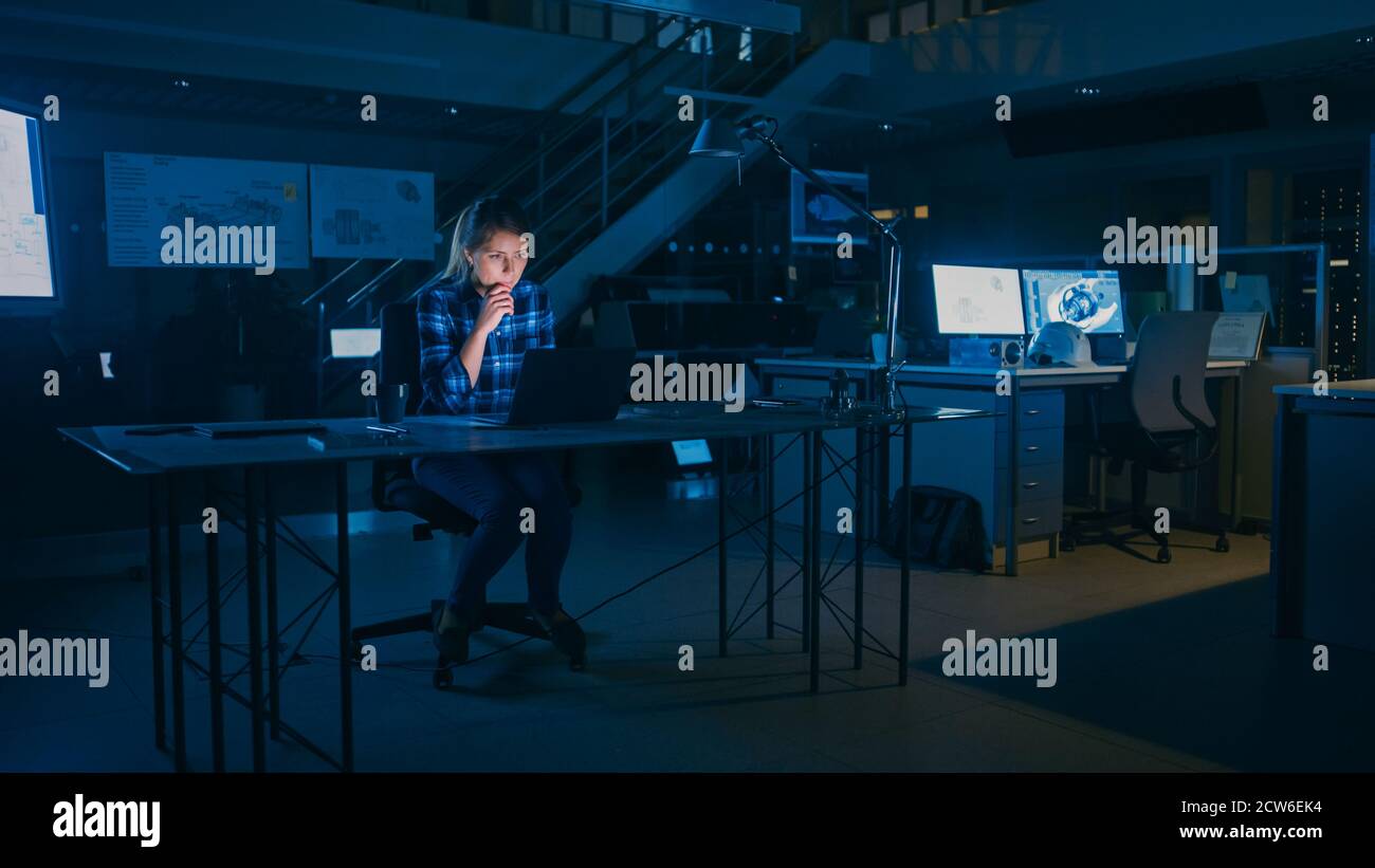 Beautiful Female Engineer Sitting at Her Desk Works on a Laptop ...