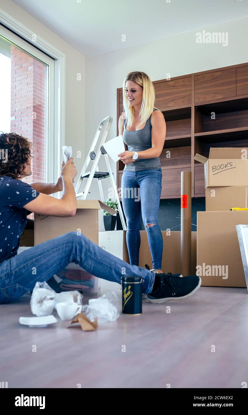 Couple unpacking moving boxes Stock Photo - Alamy