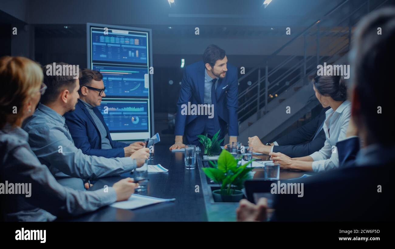 Late at Night in the Meeting Room: Handsome Executive Director Stands ...