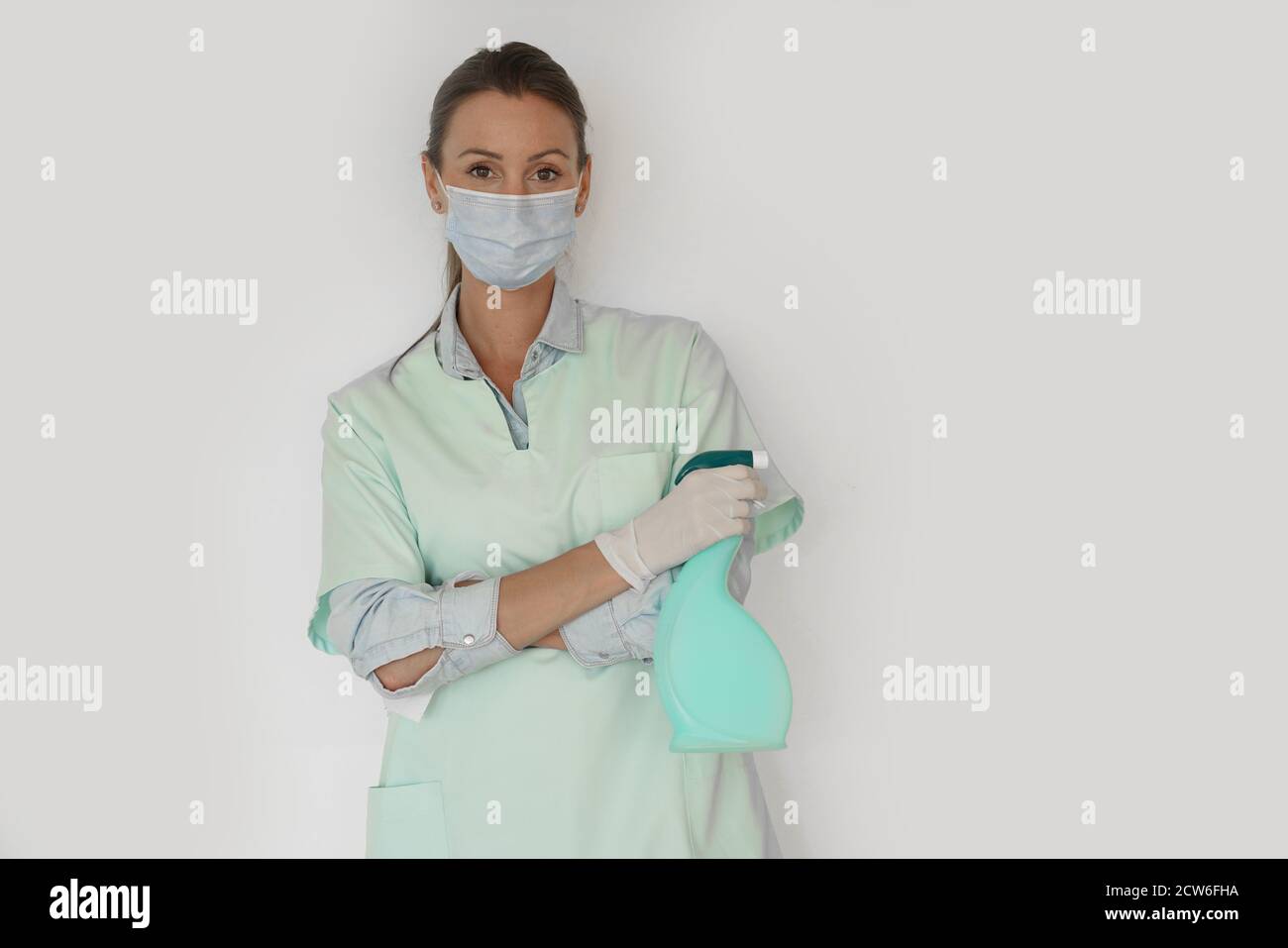 Cleaning woman with protection mask and gloves standing on white ...