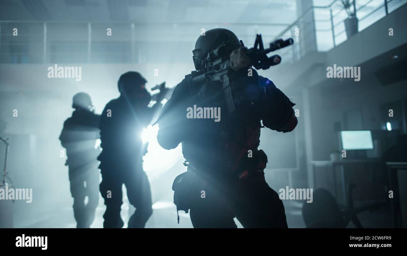 Masked Squad of Armed SWAT Police Officers Move in a Hall of a Dark ...