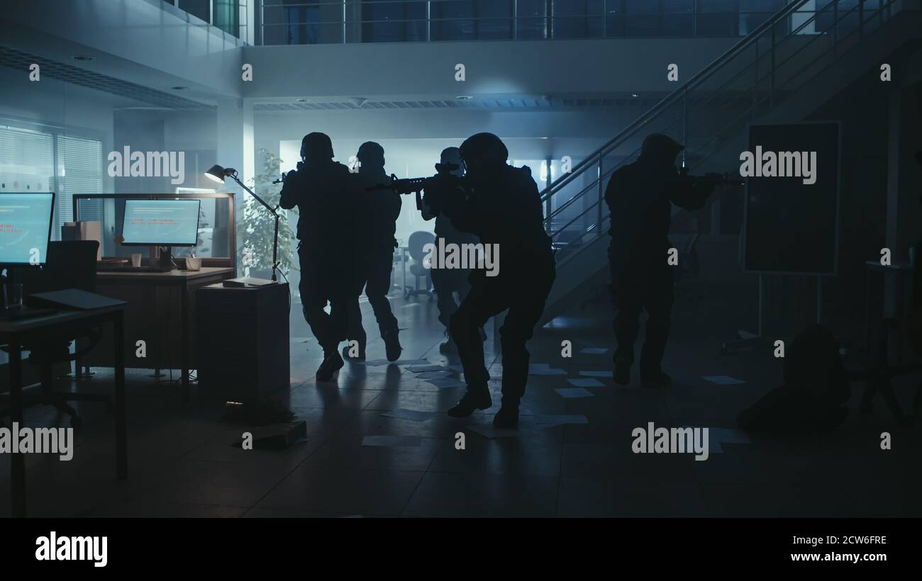 Masked Team of Armed SWAT Police Officers Move in a Hall of a Dark ...