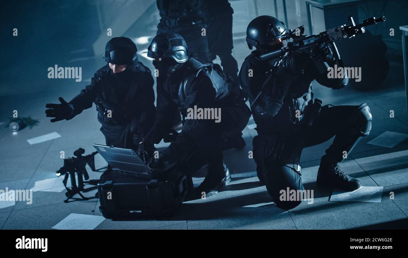 Masked Team of Armed SWAT Police Officers with Rifles are in Dark ...