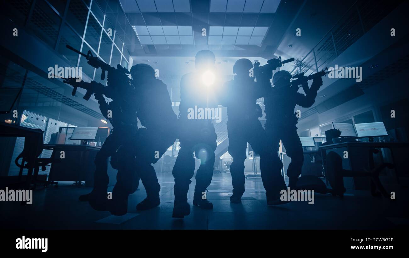 Masked Team of Armed SWAT Police Officers Move in a Hall of a Dark ...