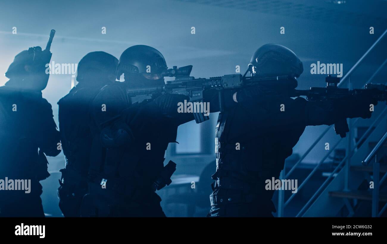 Masked Squad of Armed SWAT Police Officers Move in a Hall of a Dark ...