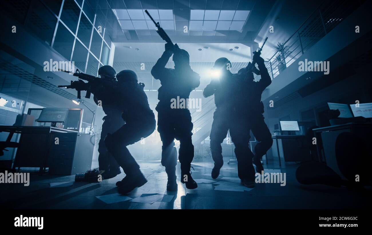 Masked Team of Armed SWAT Police Officers Move in a Hall of a Dark ...