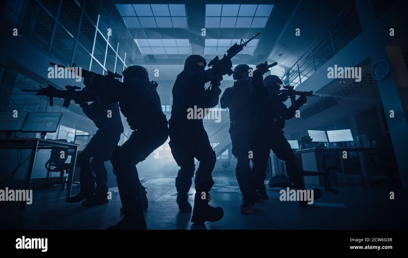 Masked Team of Armed SWAT Police Officers Move in a Hall of a Dark ...