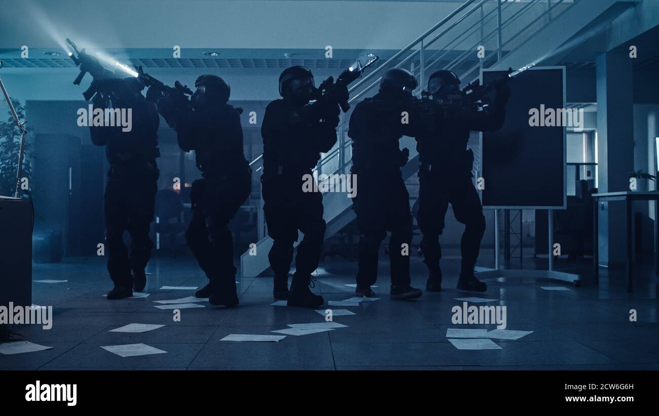 Masked Team of Armed SWAT Police Officers Move in a Hall of a Dark ...