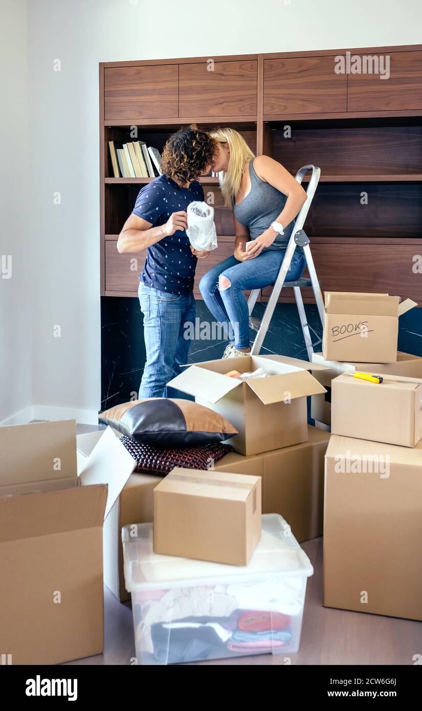 Couple kissing while unpacking boxes Stock Photo - Alamy