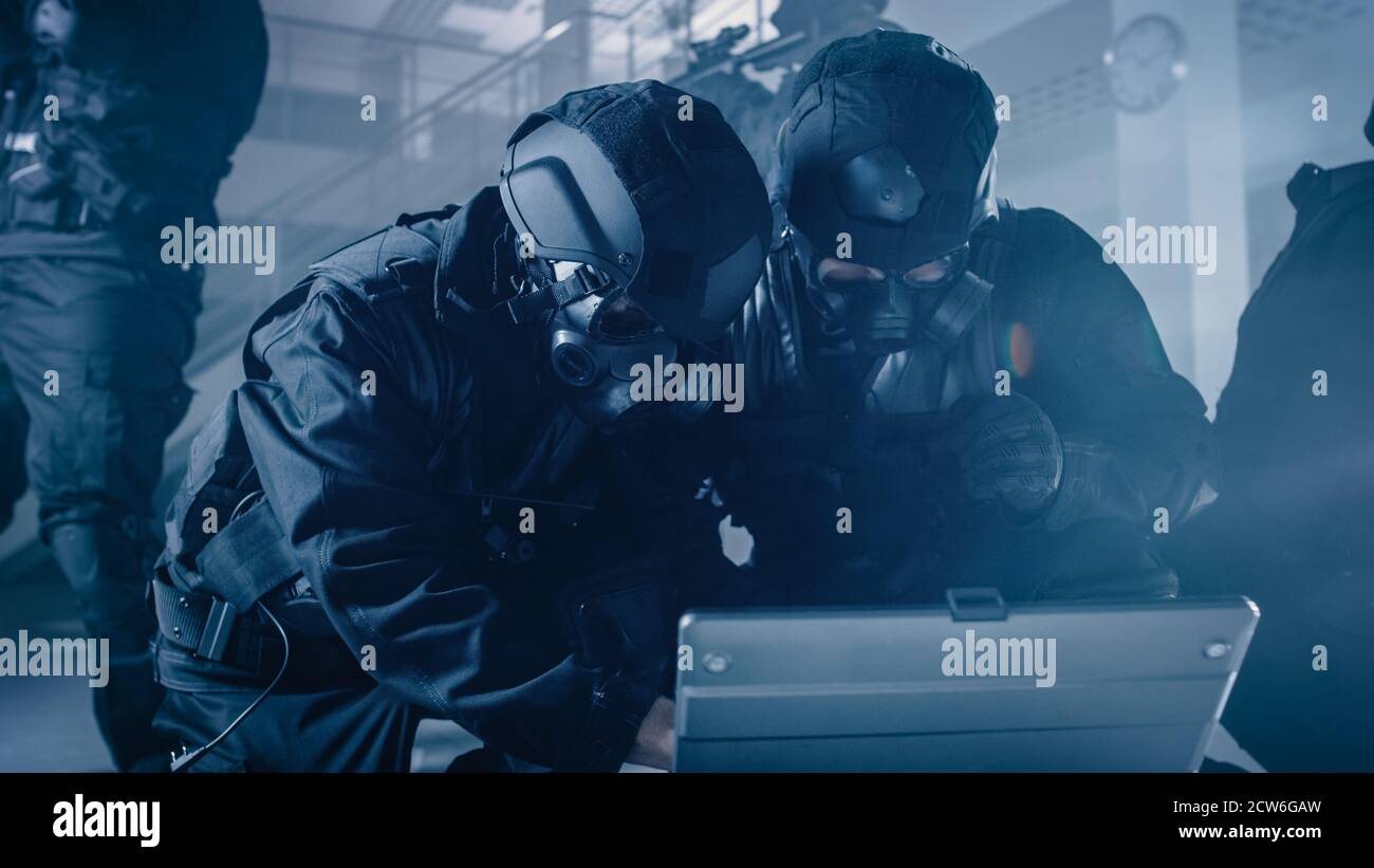 Masked Team of Armed SWAT Police Officers with Rifles are in Dark ...