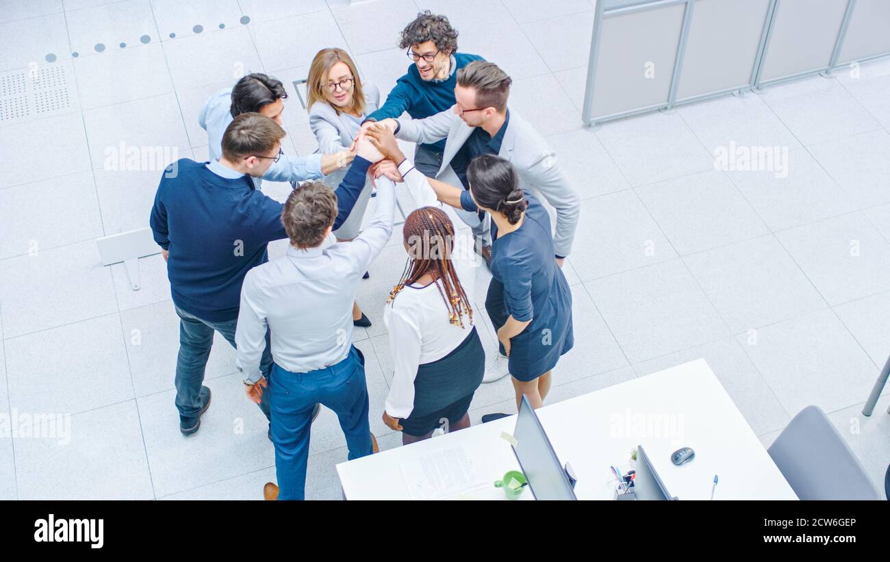 Eight Successful Office Workers doing Team Building Exercise Stacking ...
