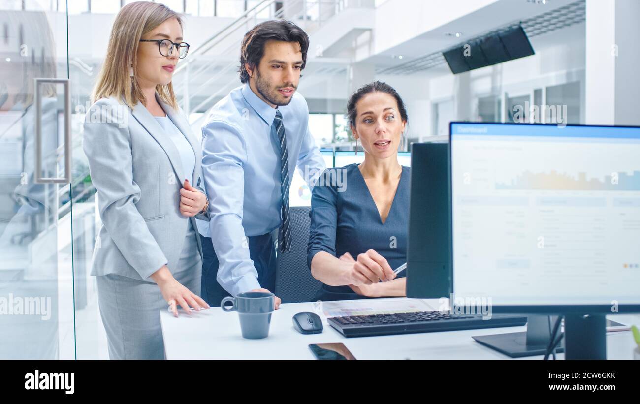 In Bright Modern Office: Office Worker Sitting and Working at Her ...