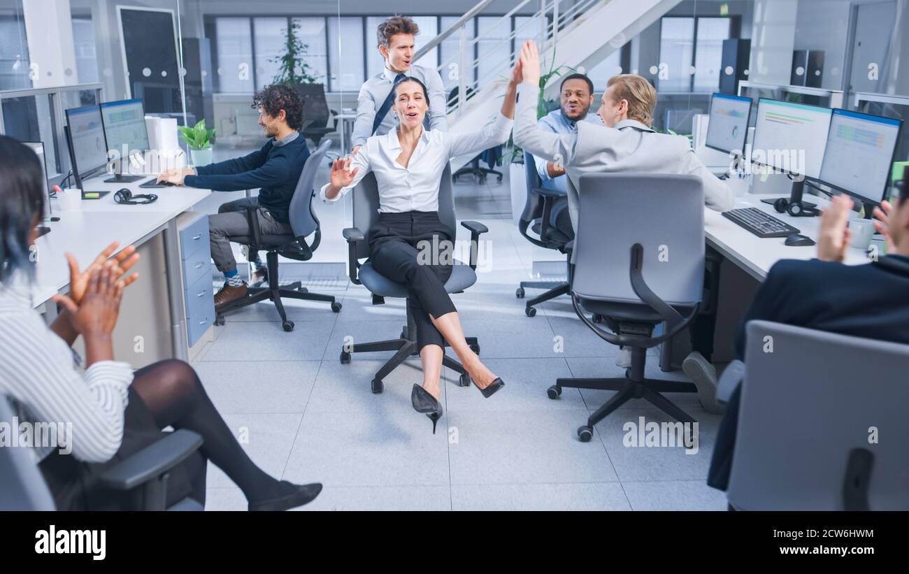 Cheerful Employee Pushes His Beautiful Female Colleague on a Chair ...