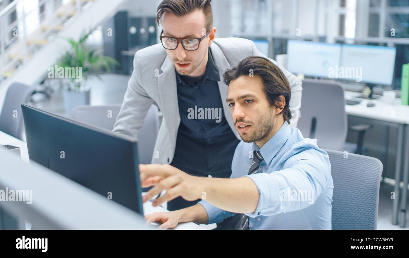 In Bright Modern Office: Handsome Office Worker Sitting and Working at ...