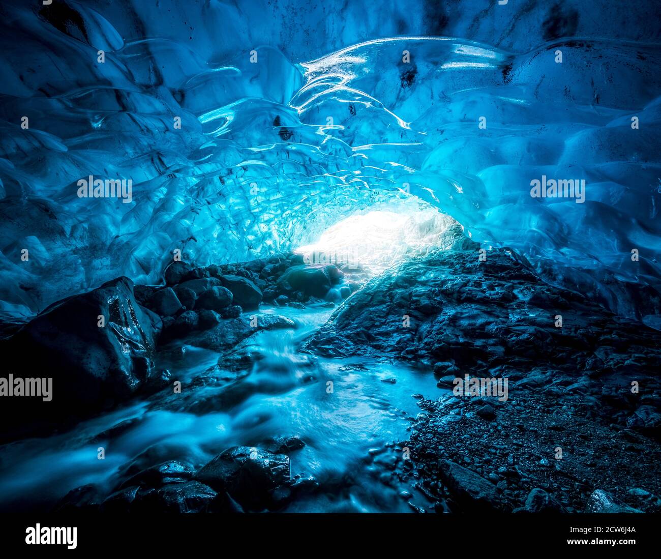 Entrance of an crystal blue ice cave with underground river inside ...