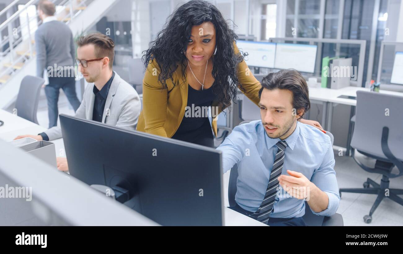 In Bright Modern Office: Handsome Office Worker Sitting and Working at ...