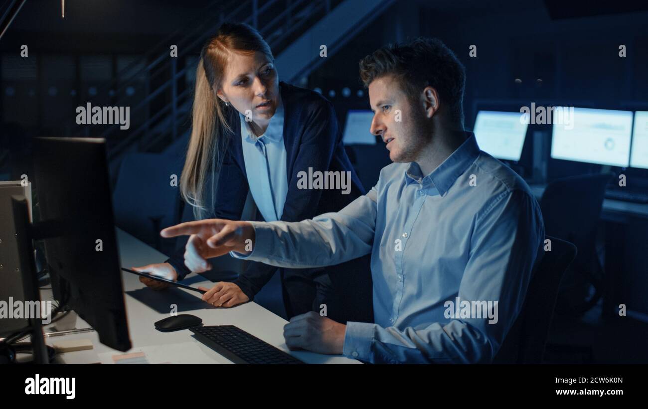 Ambitious and Confident Businessman Uses Desktop Computer, His Female ...