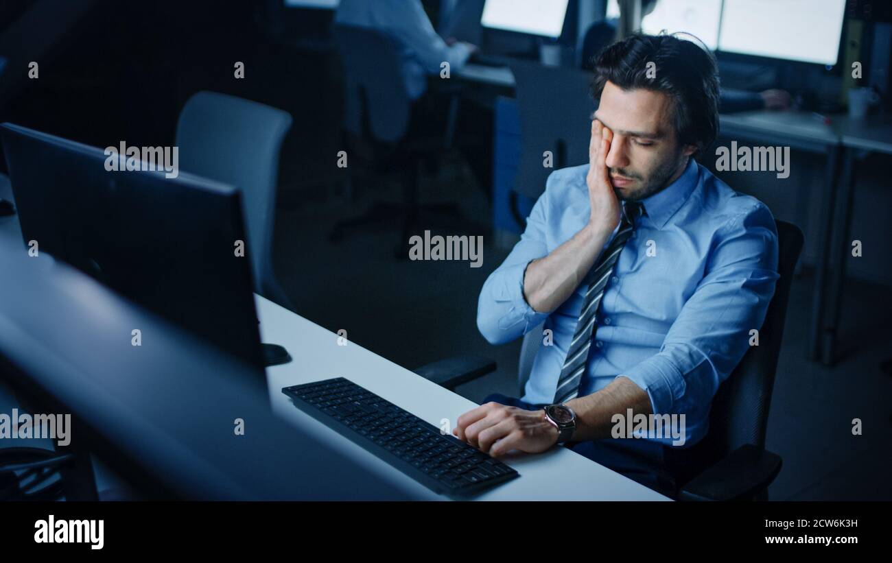 In the Office at Night Overworked Tired Office Worker Uses Desktop ...