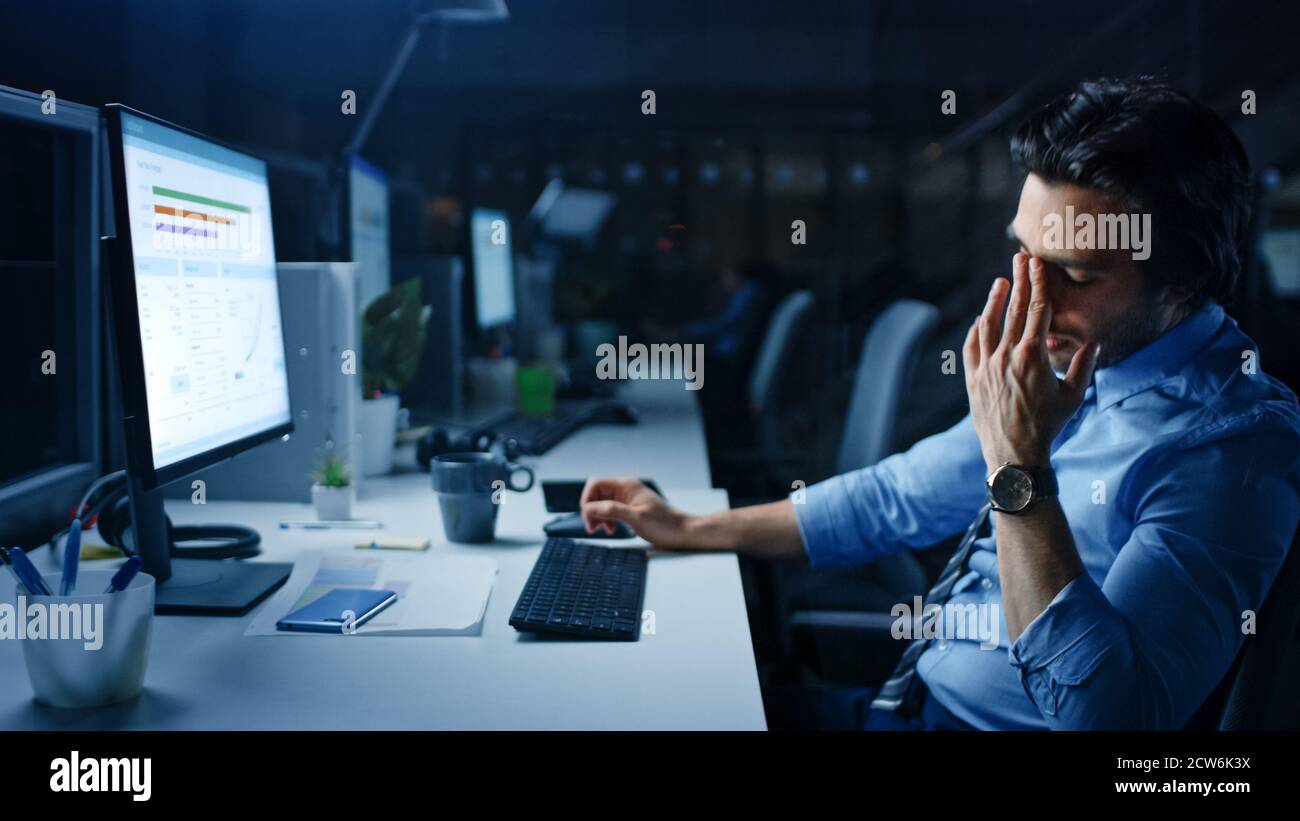 In the Office at Night Overworked Tired Office Worker Uses Desktop ...