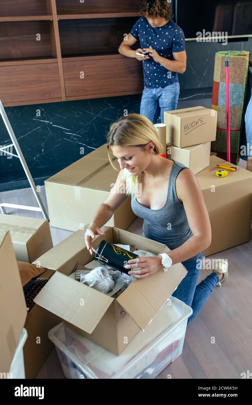 Woman unpacking moving boxes Stock Photo - Alamy