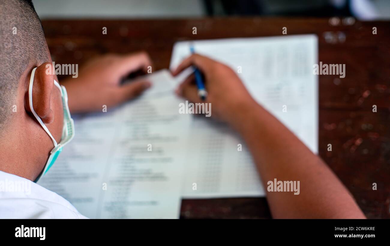 Student wearing mask for protect corona virus or covid-19 and doing ...