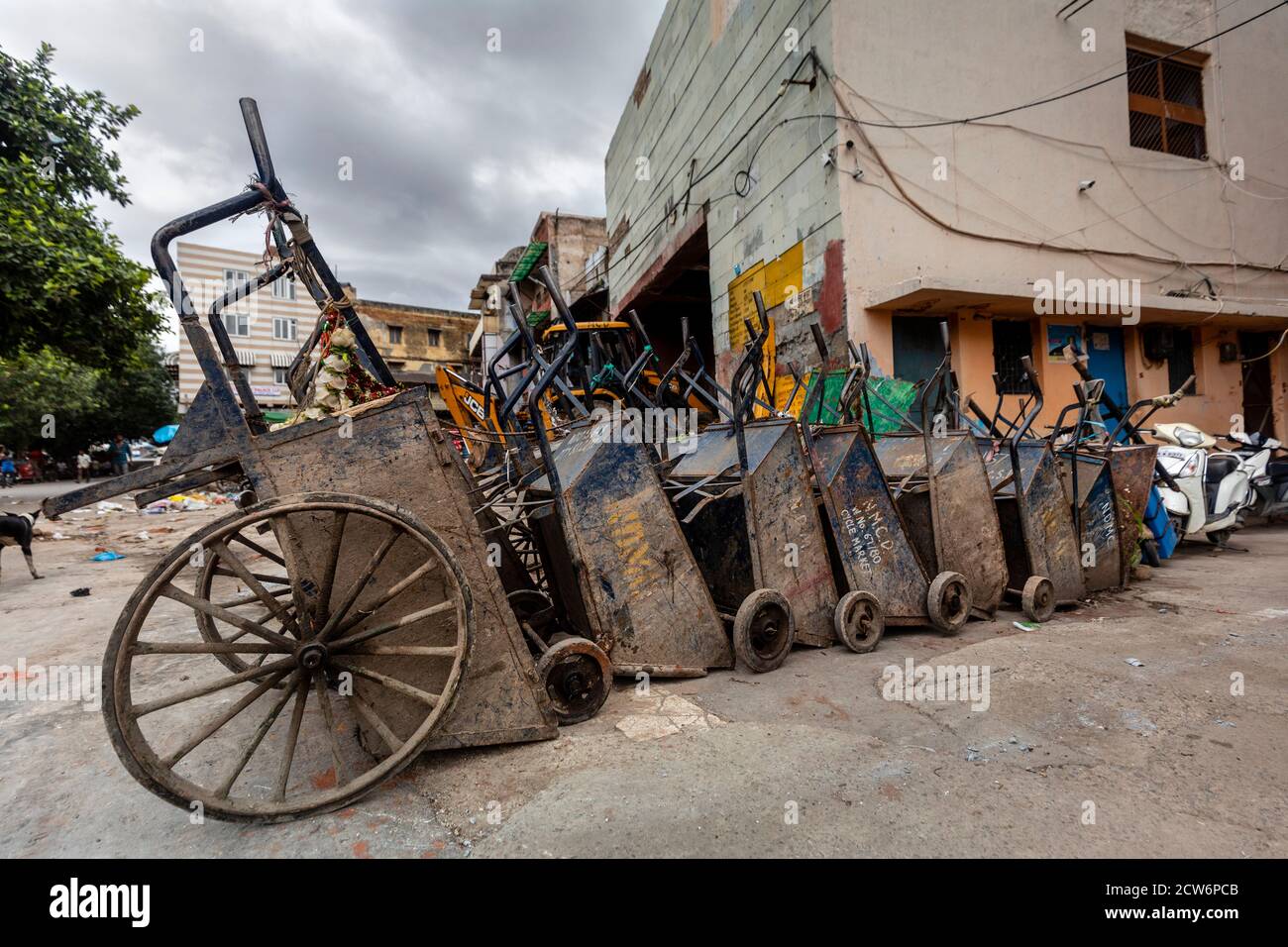 A series of garbage collection carts lined up near a dumping yard in ...