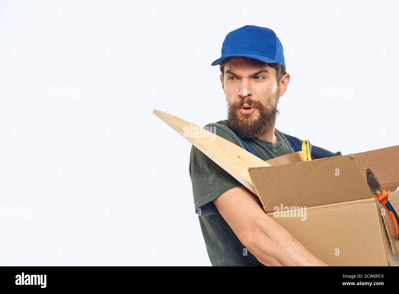 Worker man in uniform with a box in his hands tools delivery service ...