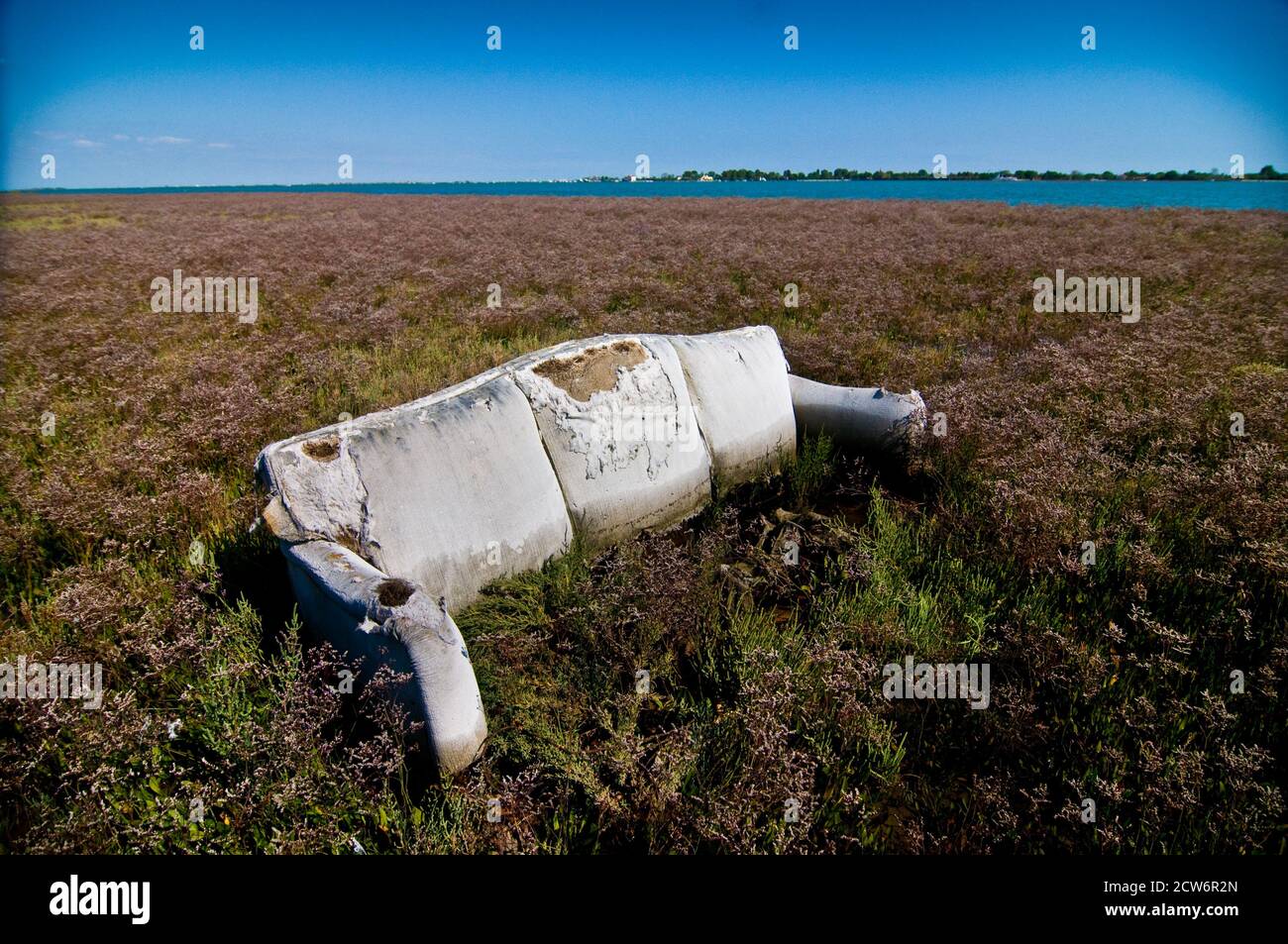 A ruin sofa lost in a field among weeds Stock Photo - Alamy