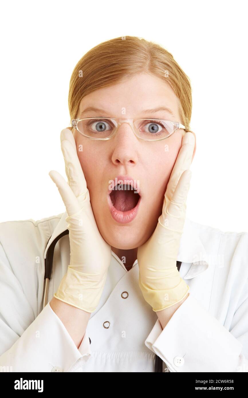 Shocked blonde female doctor holds her hands to her face Stock Photo ...