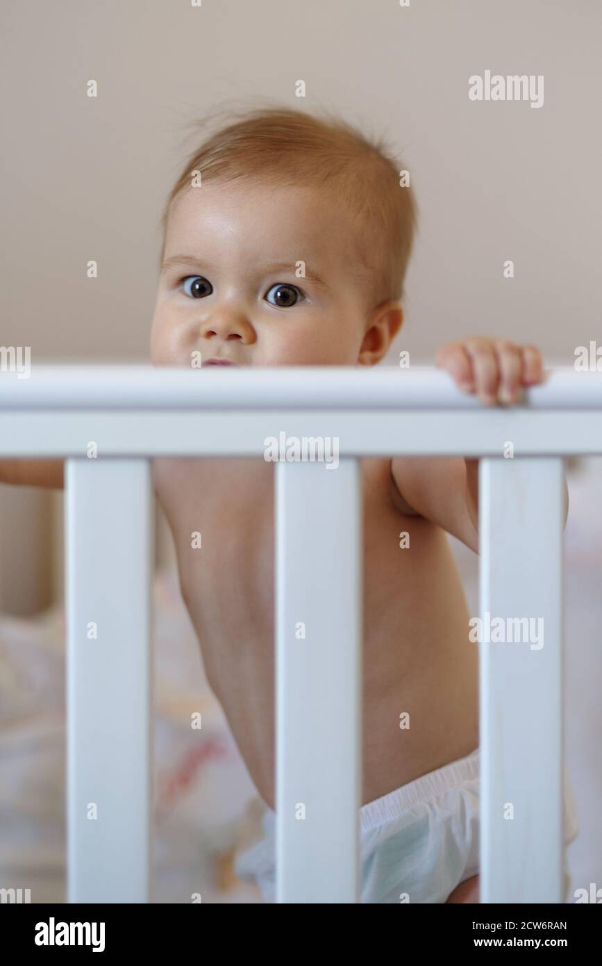 8 month old baby girl standing in the crib Stock Photo - Alamy