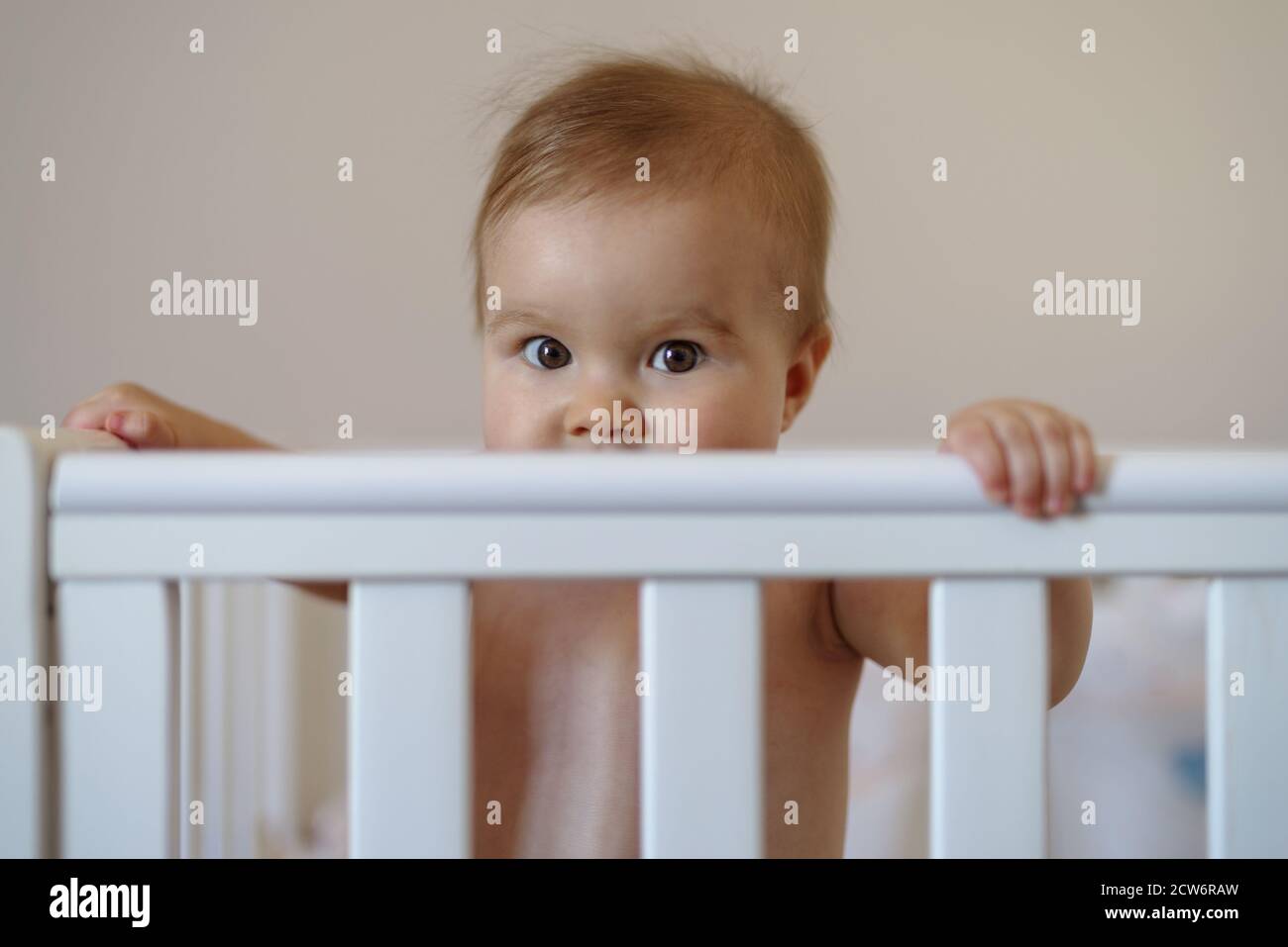 8 month old baby girl standing in the crib Stock Photo - Alamy