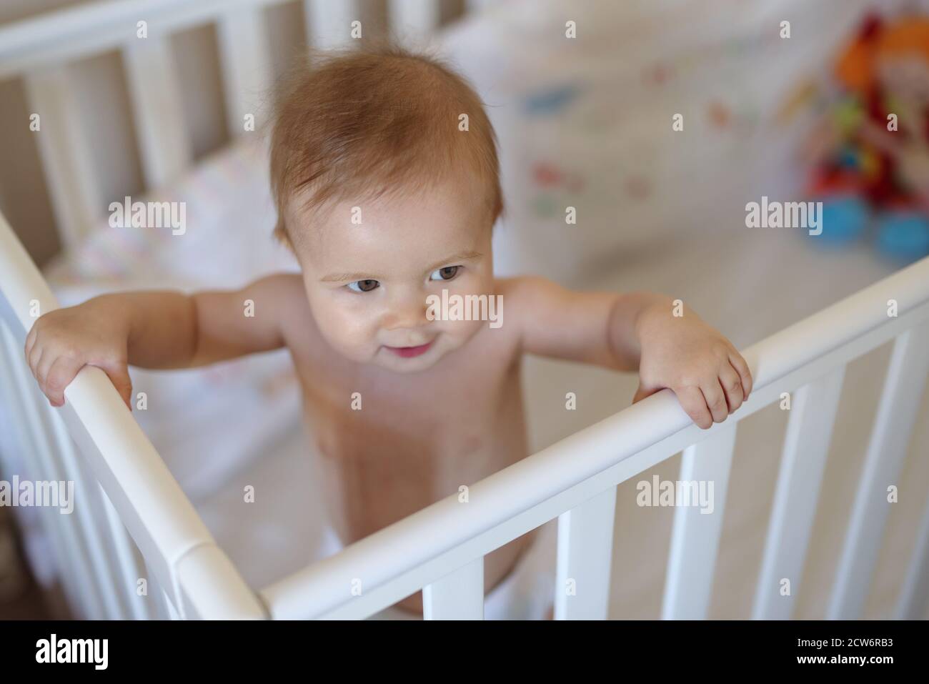 8 month old baby girl standing in the crib Stock Photo - Alamy