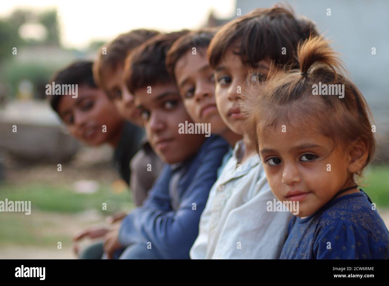 group of children sitting in row Stock Photo - Alamy