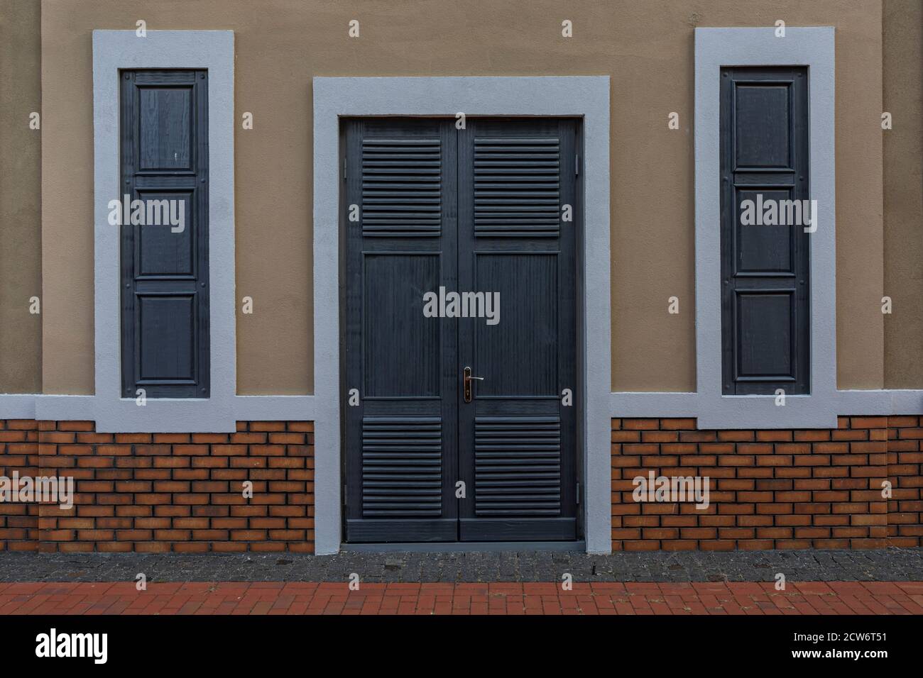 Wall with wooden doors and closed windows Stock Photo - Alamy