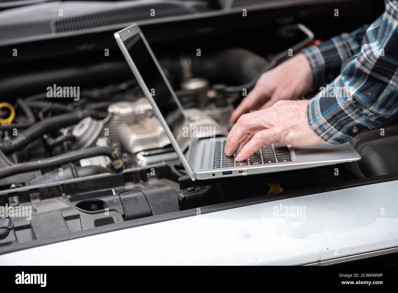 Car mechanic using laptop for checking car engine Stock Photo - Alamy