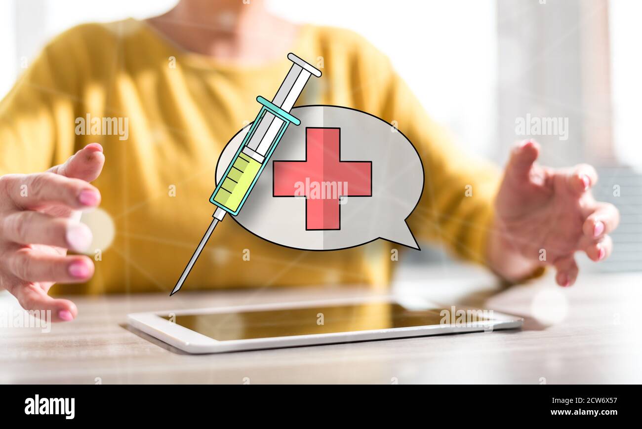 Digital tablet with vaccination campaign concept between hands of a ...