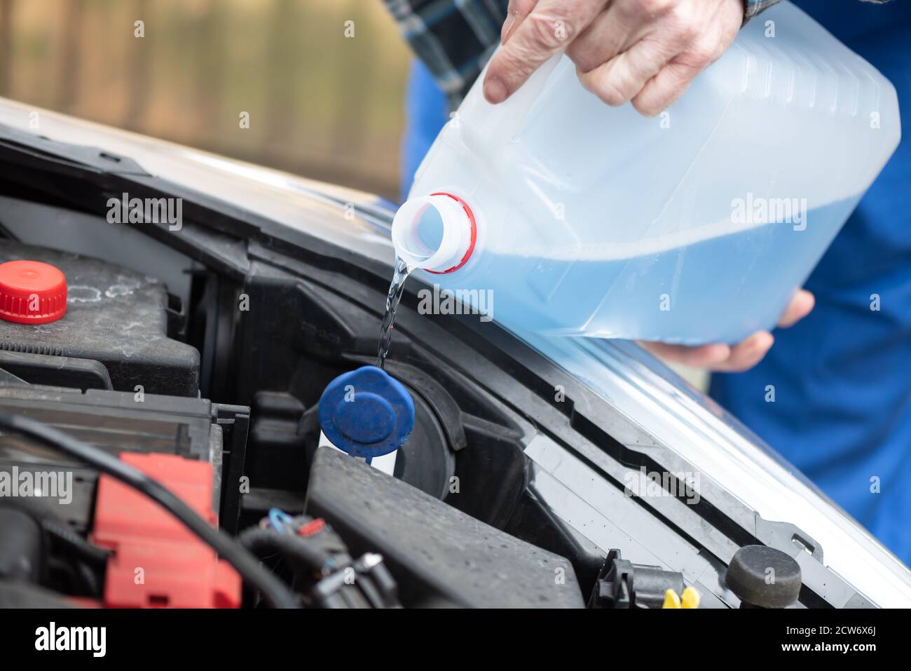 Hands of mechanic pouring blue windshield washer fluid in a car Stock ...
