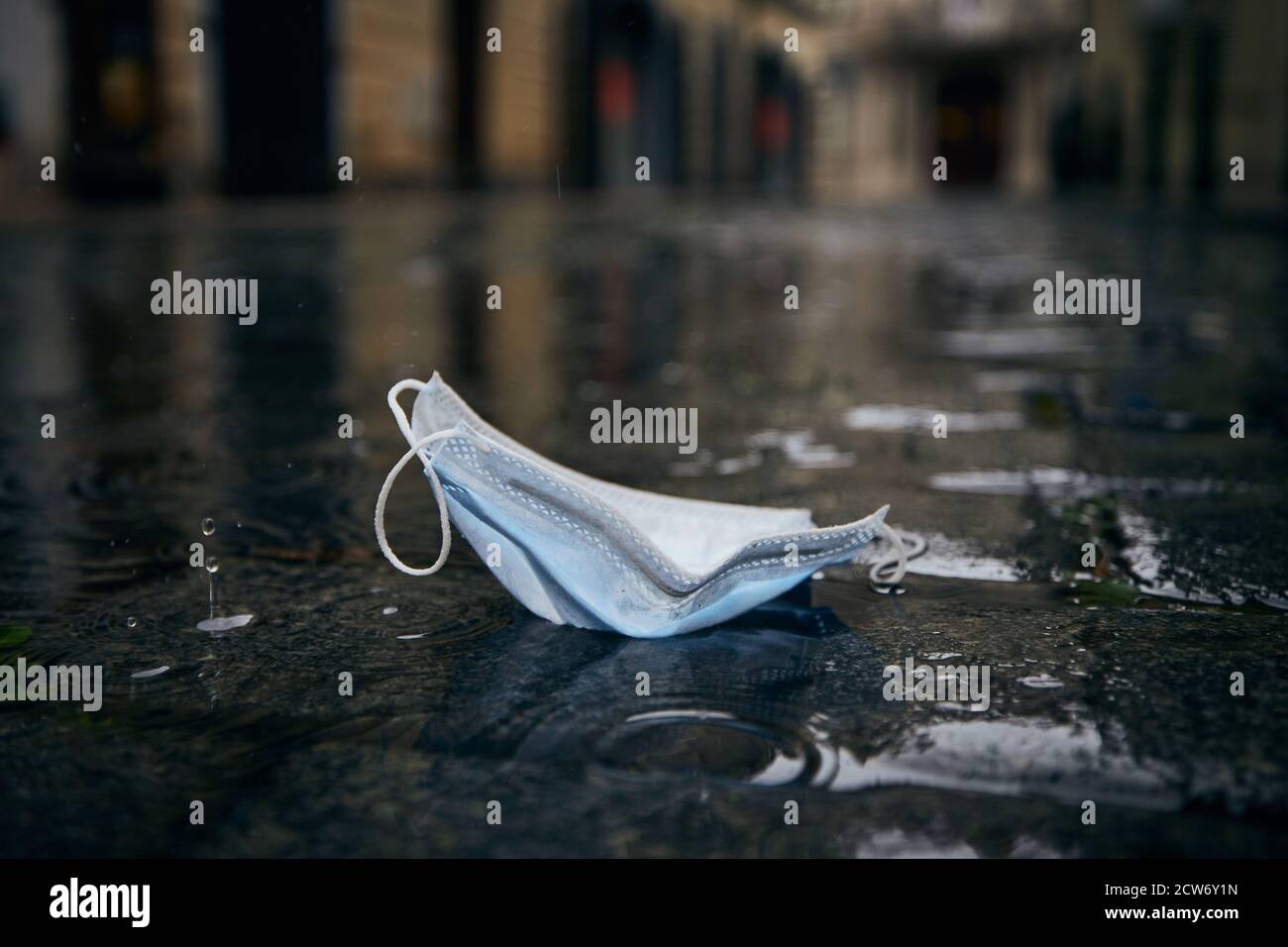 Used disposable face mask in puddle during rain. Themes coronavirus ...
