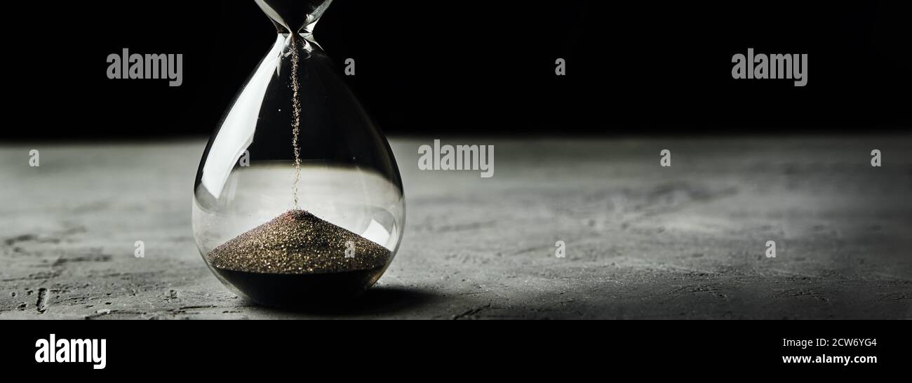 Hourglass on dark background, long banner. Urgency and running out of ...