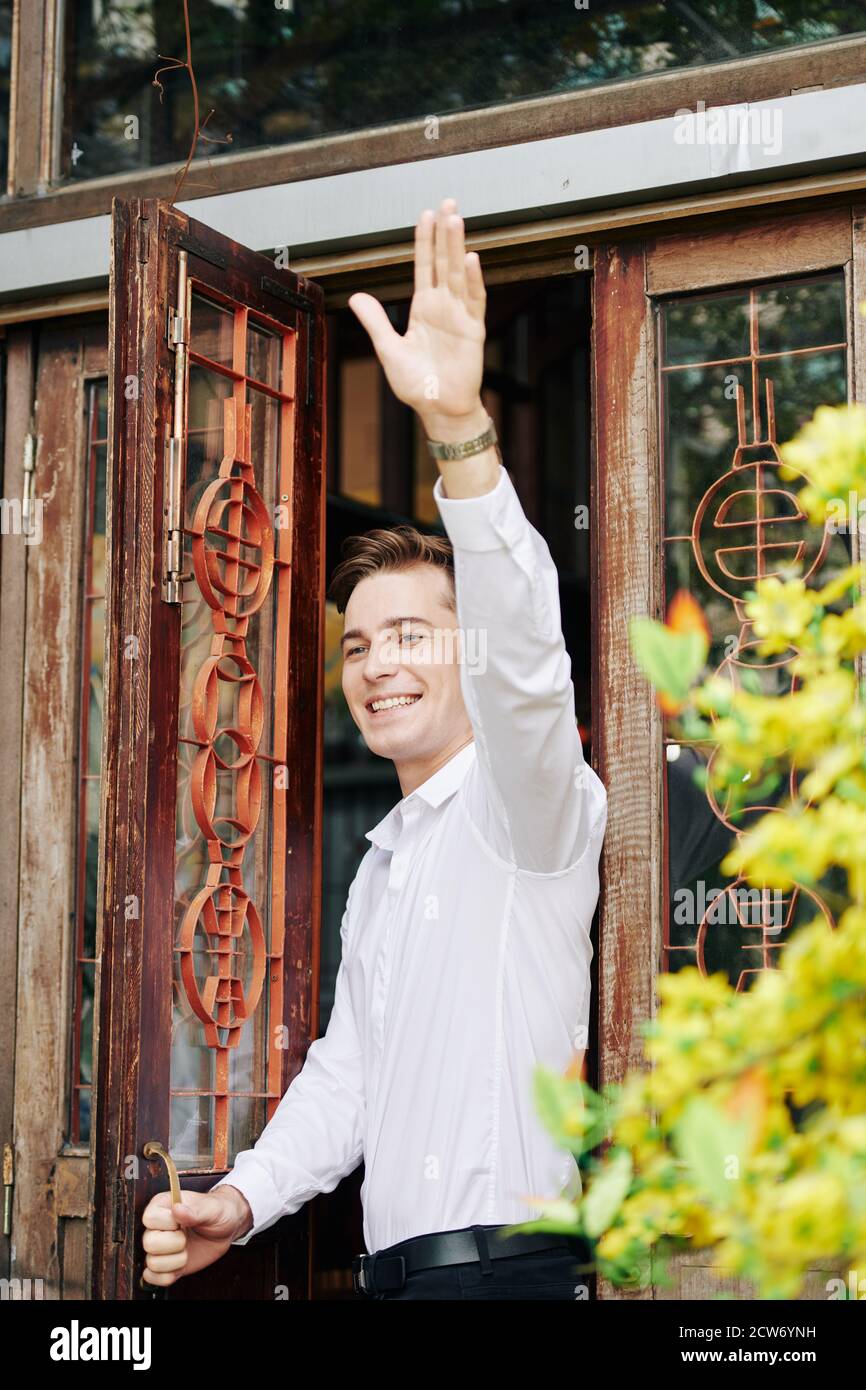 Man waving to friend Stock Photo - Alamy