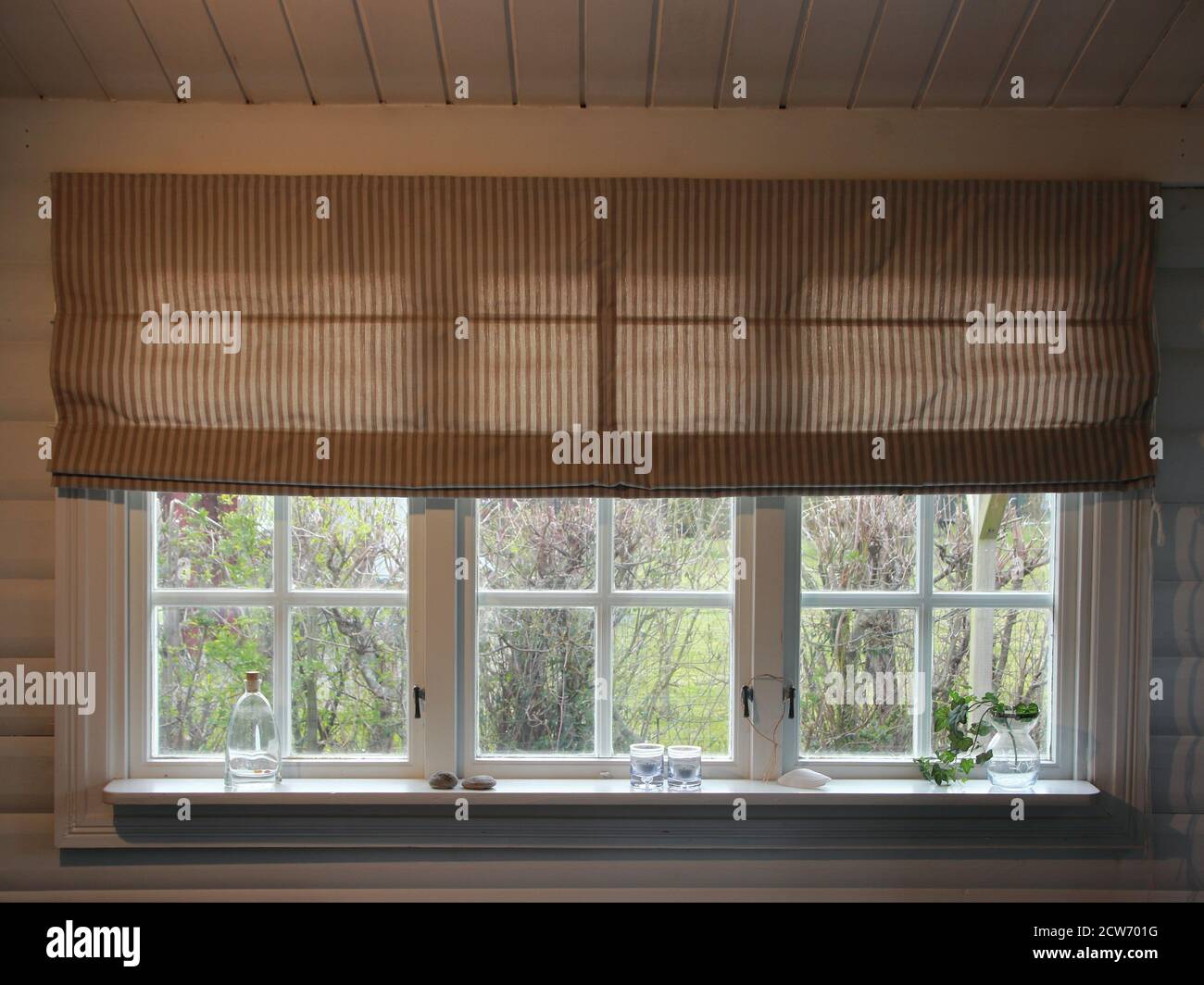 A vintage three-part window with a white frame. The windowsill has ...