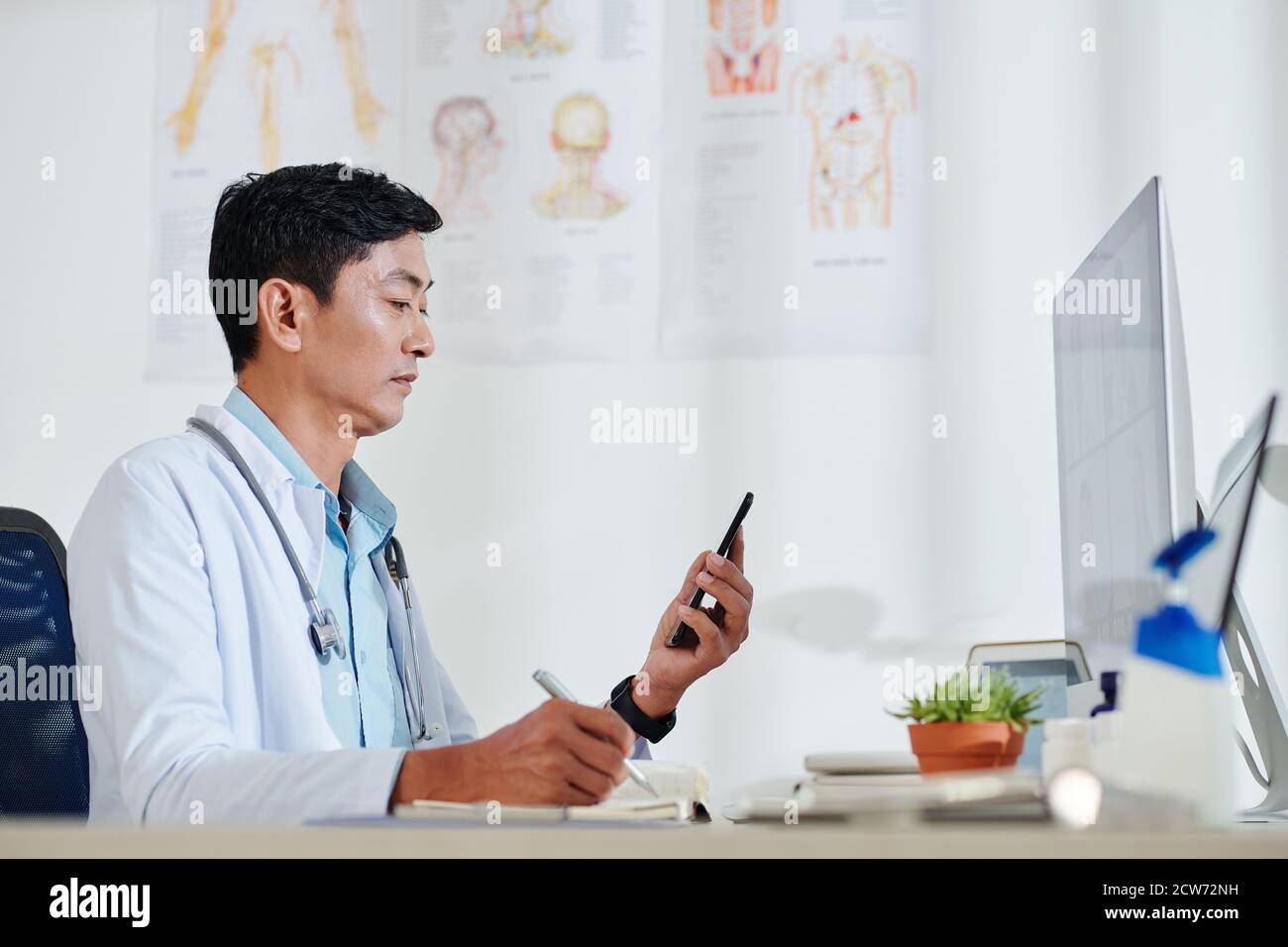 Doctor checking text messages Stock Photo - Alamy