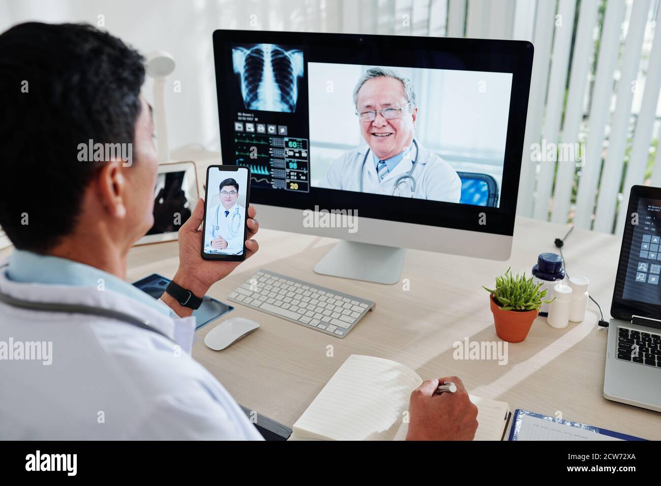 Doctor video calling colleagues Stock Photo - Alamy