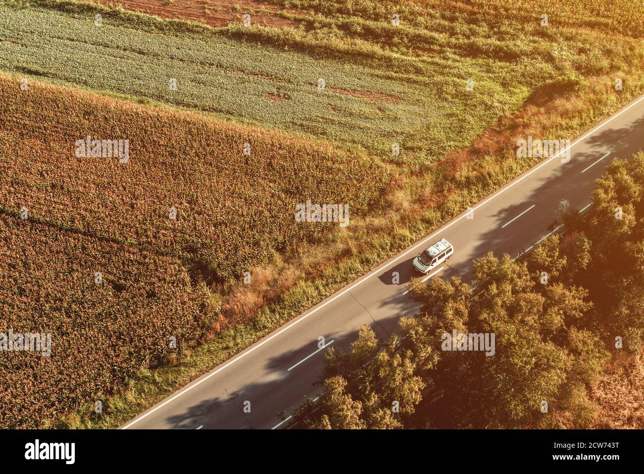 Aerial view of minivan on the road through countryside from drone pov ...
