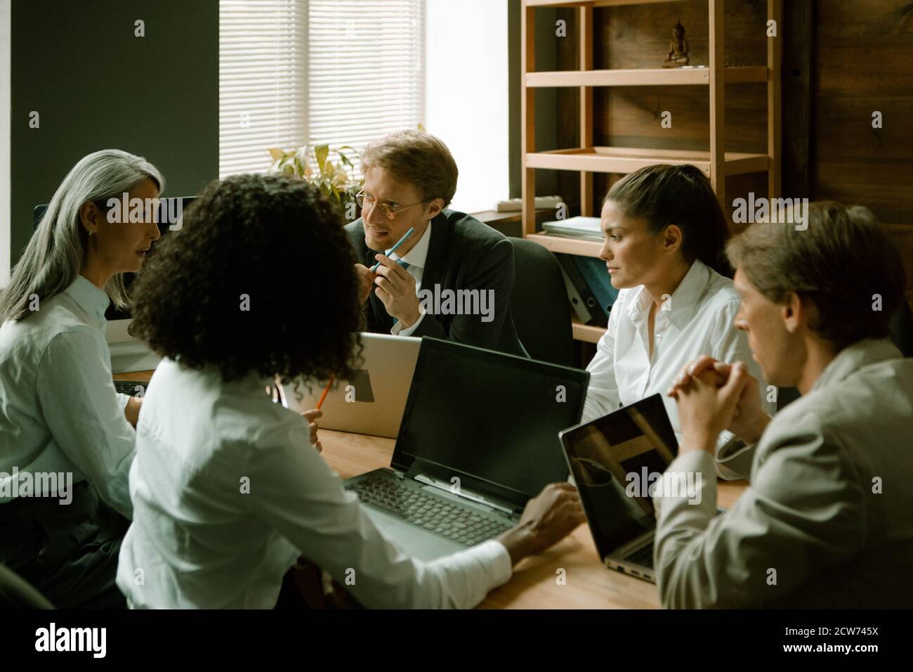 Business meeting in the office. Office workers sit at a table working ...