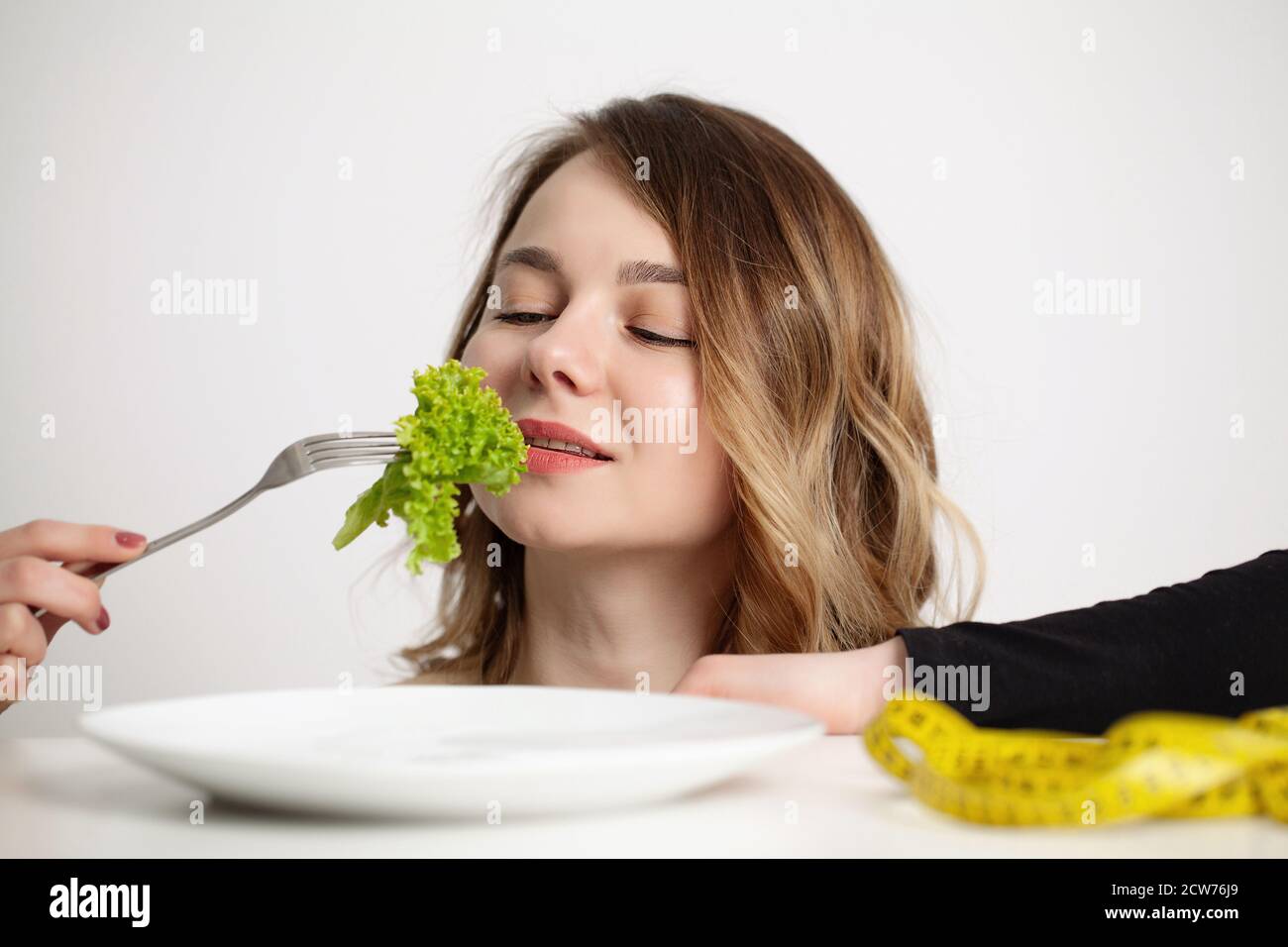 Portrait of happy smiling young beautiful woman eating broccoli Stock ...