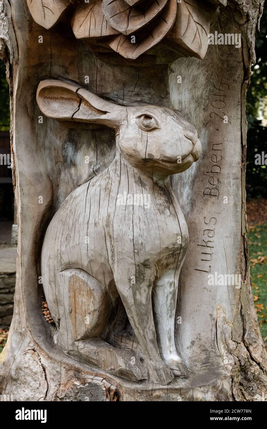 Carved wooden hare detail at base of large tree trunk sculpture in ...