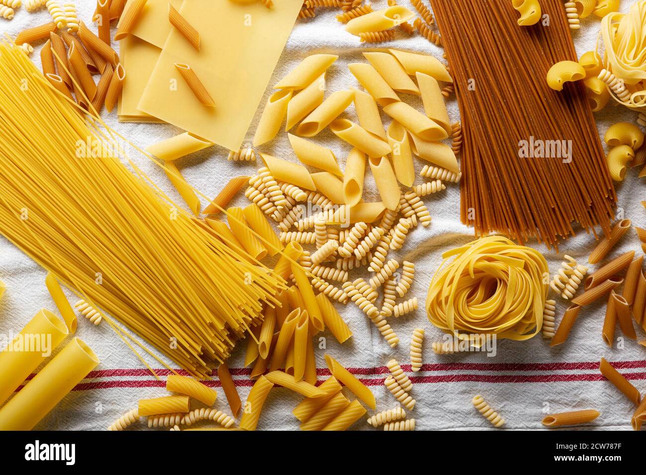 Overhead view of Different types of pasta on white textile Stock Photo ...