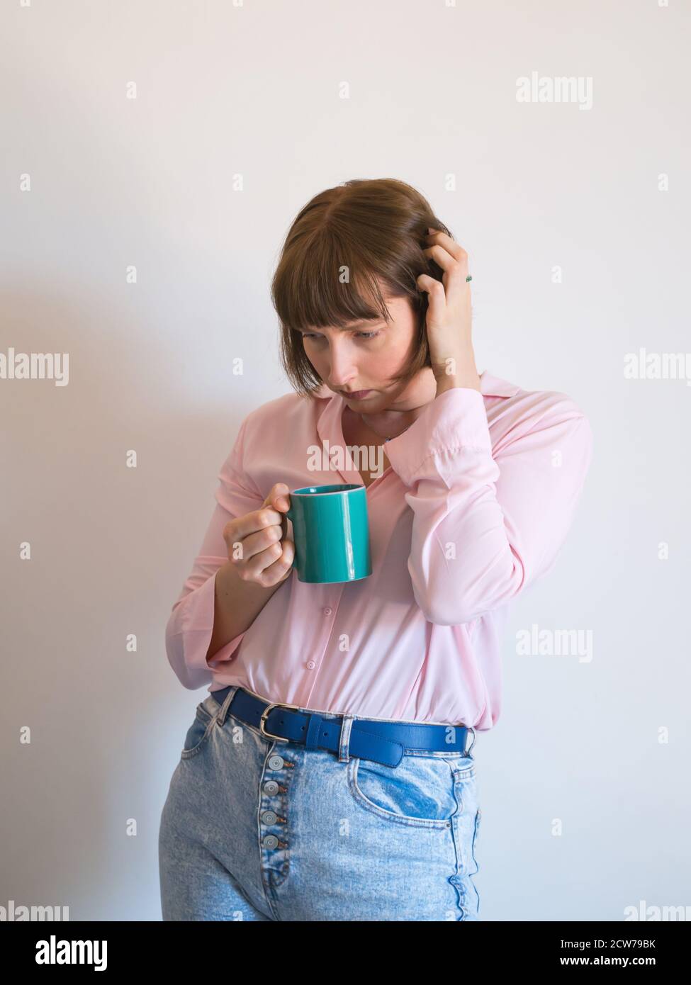 Young sad woman drinking coffee and thinking Stock Photo - Alamy